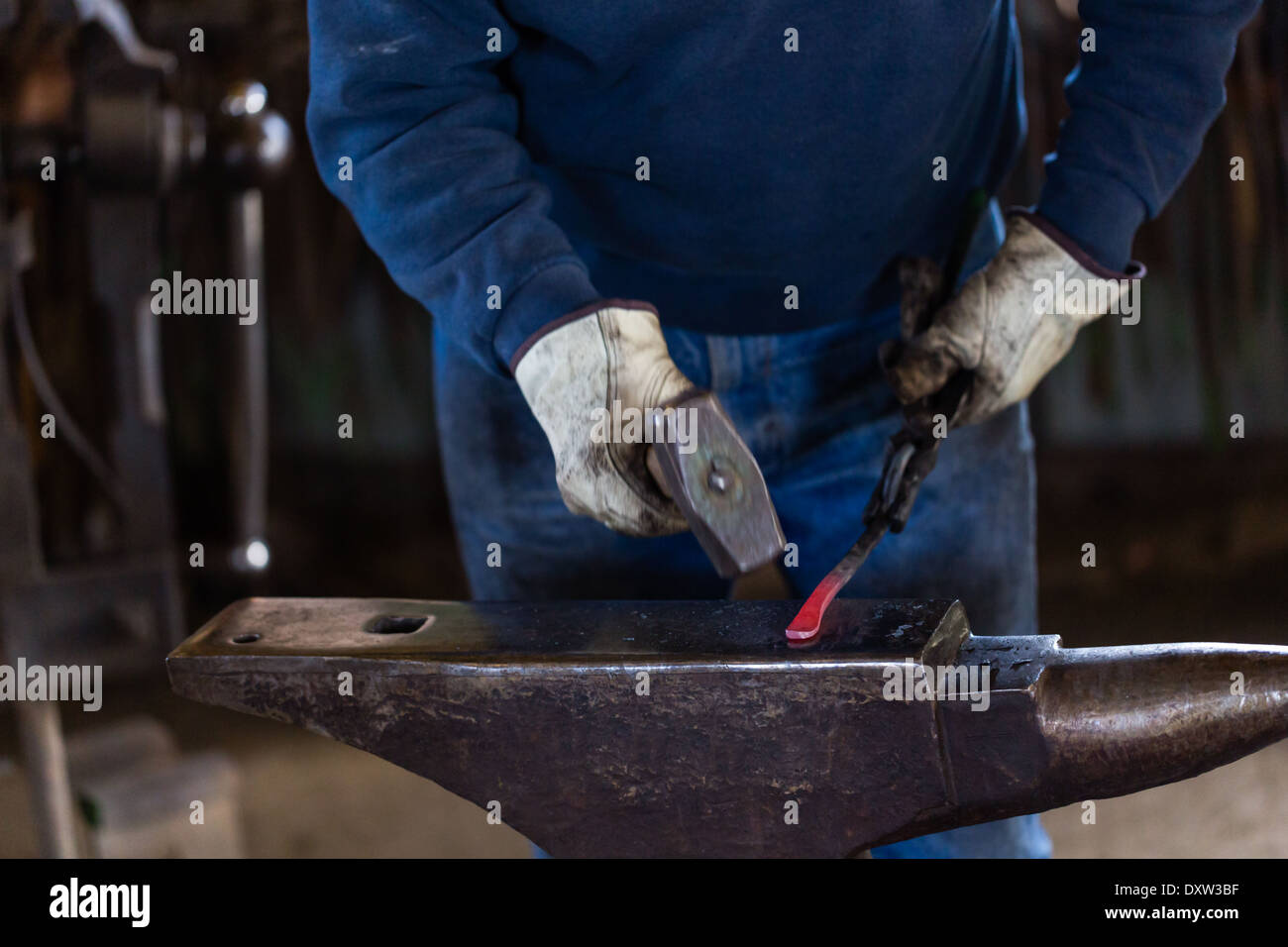 A blacksmith forging hot iron on the anvil Stock Photo - Alamy
