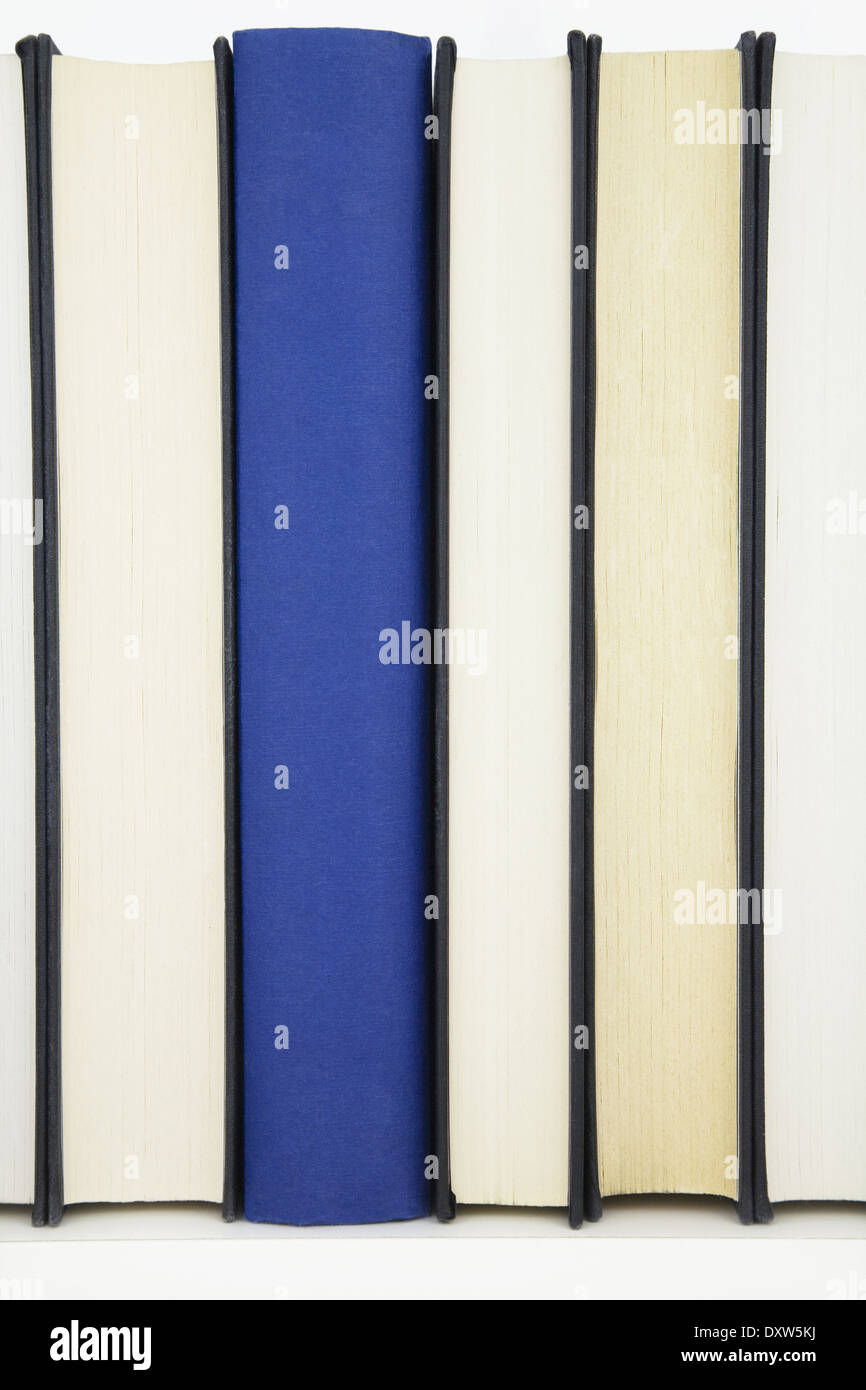 Group of books in a row and one book standing out from others with ...
