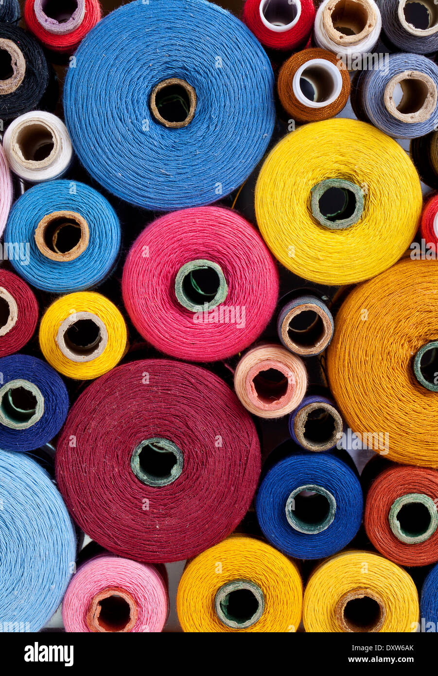 vertical close up of spools of thread of different size, texture and ...
