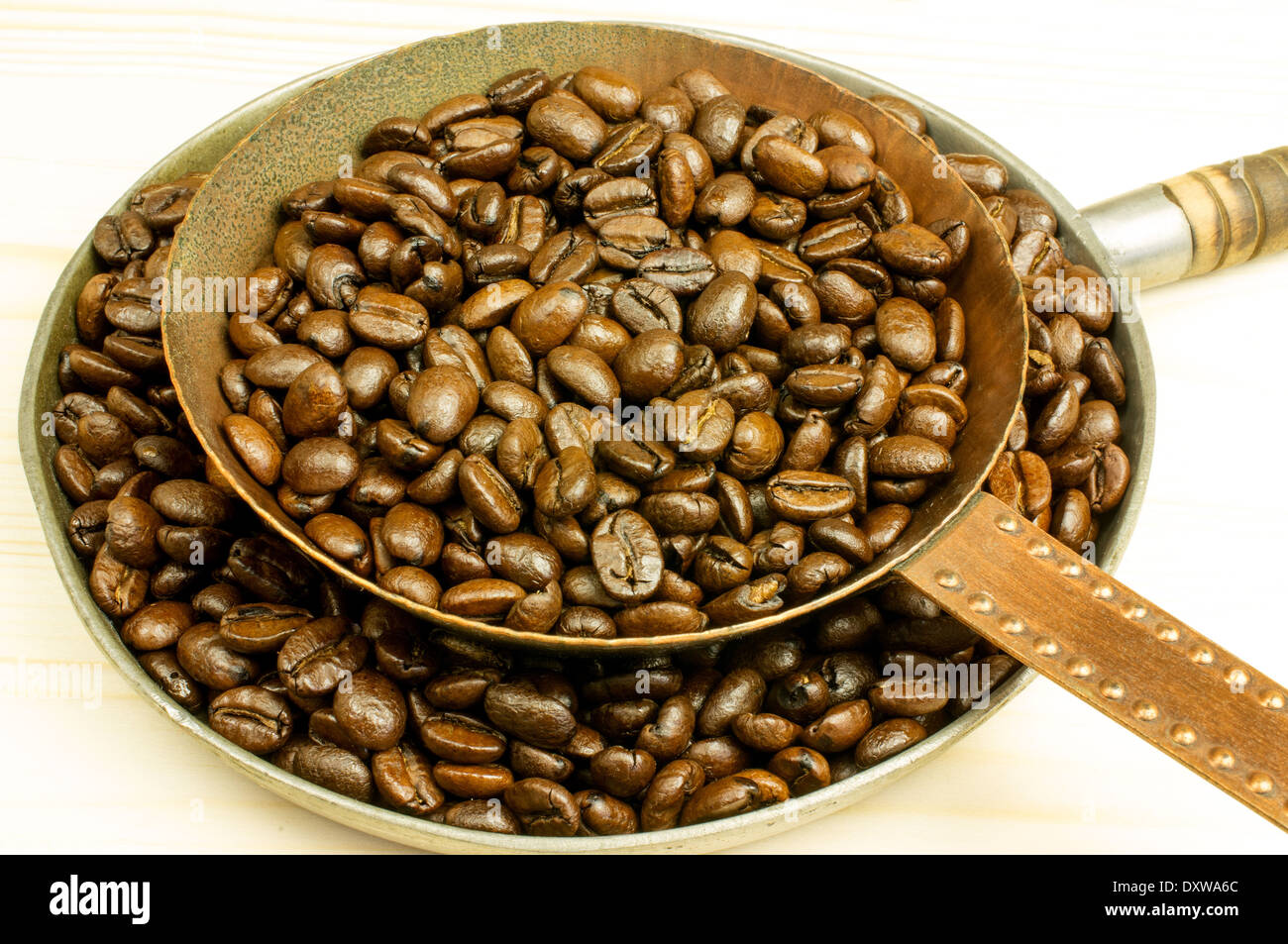 Coffee beans are roasted in a small frying pan in a large frying pan ...