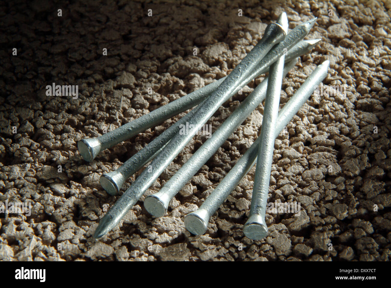 Masonry nails on a concrete block background Stock Photo - Alamy