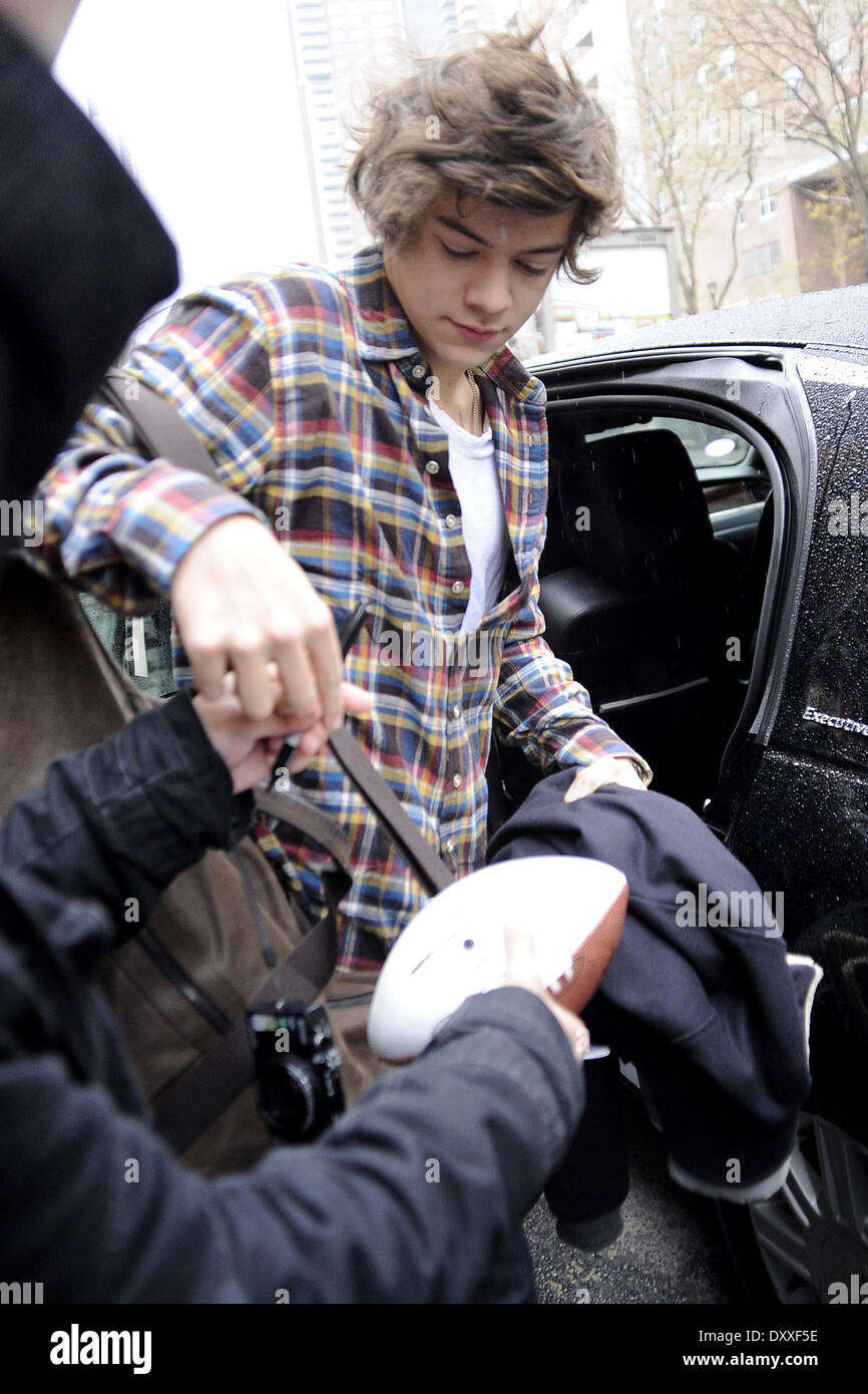 Harry Styles of One Direction signs an autograph for a fan as he leaves ...