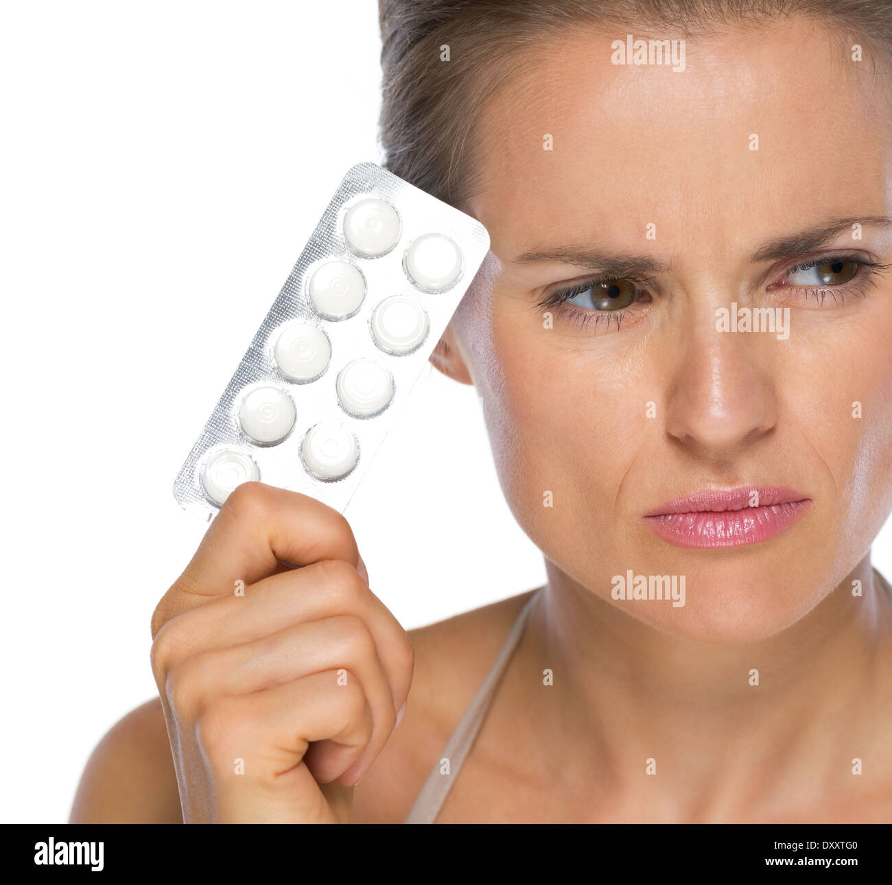 Portrait of thoughtful young woman with blistering package of pills ...