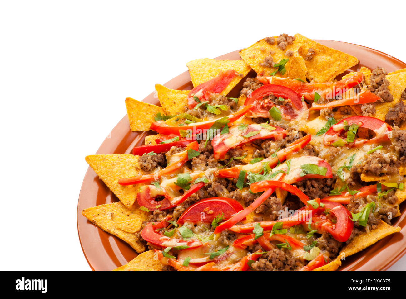 Plate of freshly made spicy nachos with pork, tomato and red pepper on ...