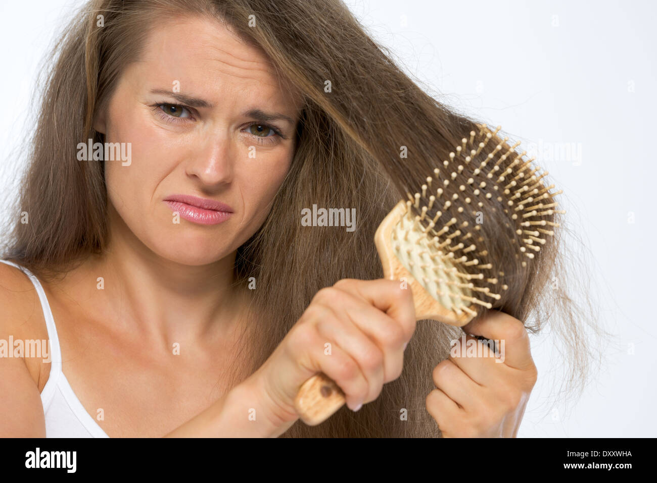 Frustrated young woman combing hair Stock Photo - Alamy