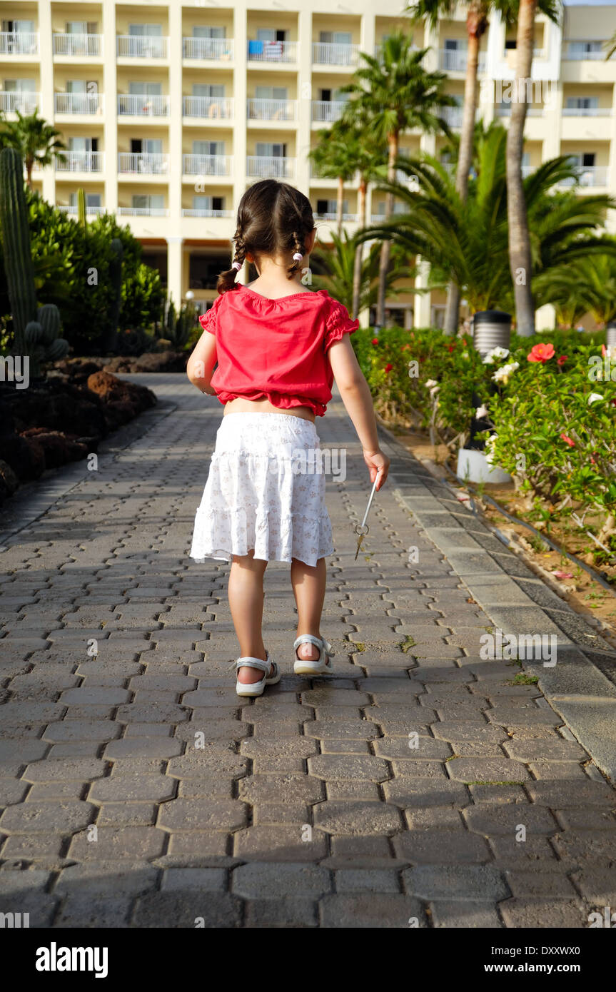 Young child walking with hotel key in her hand Stock Photo - Alamy