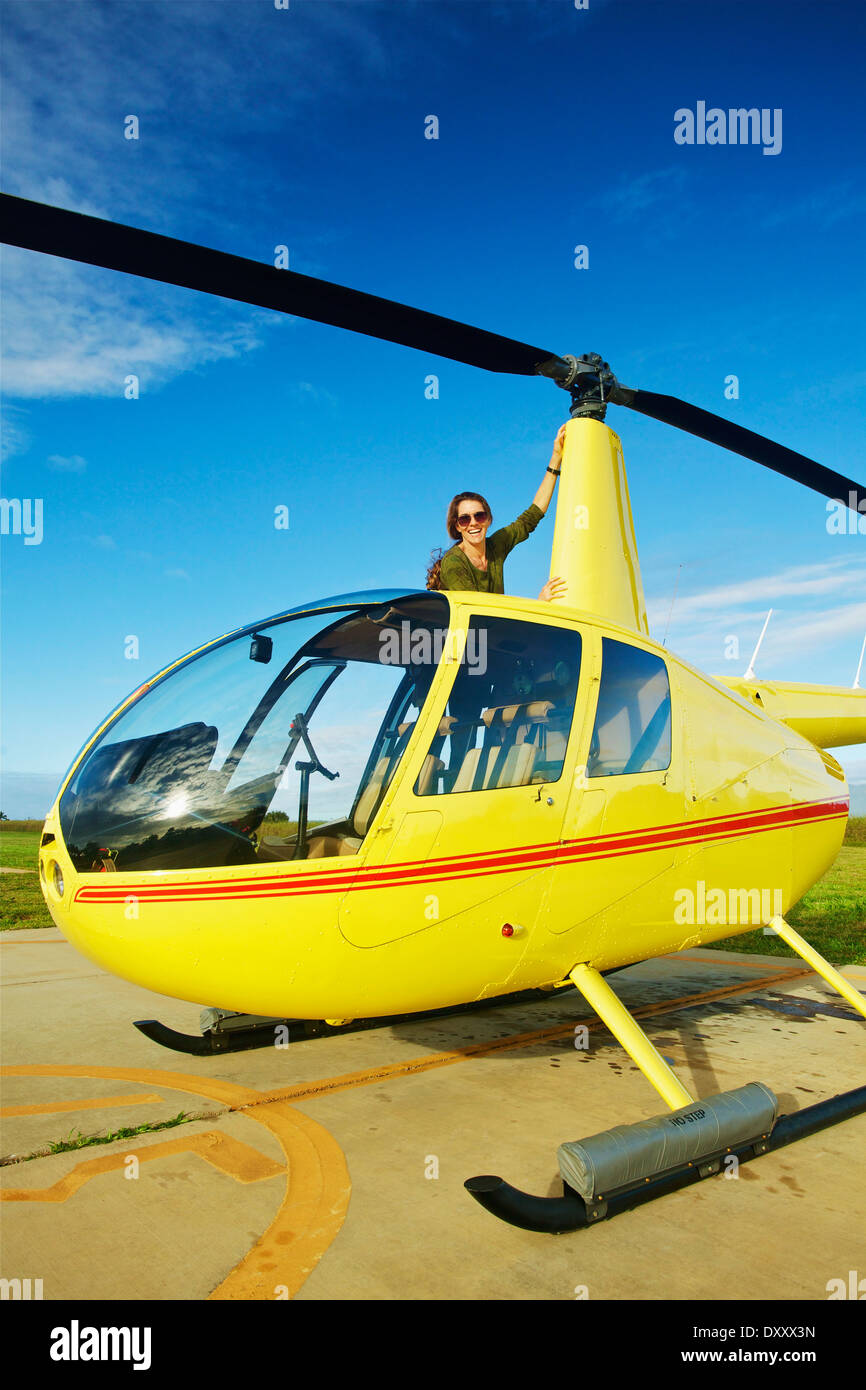 Portrait of a pilot waiting with a helicopter; Kilauea, Hawaii, United ...