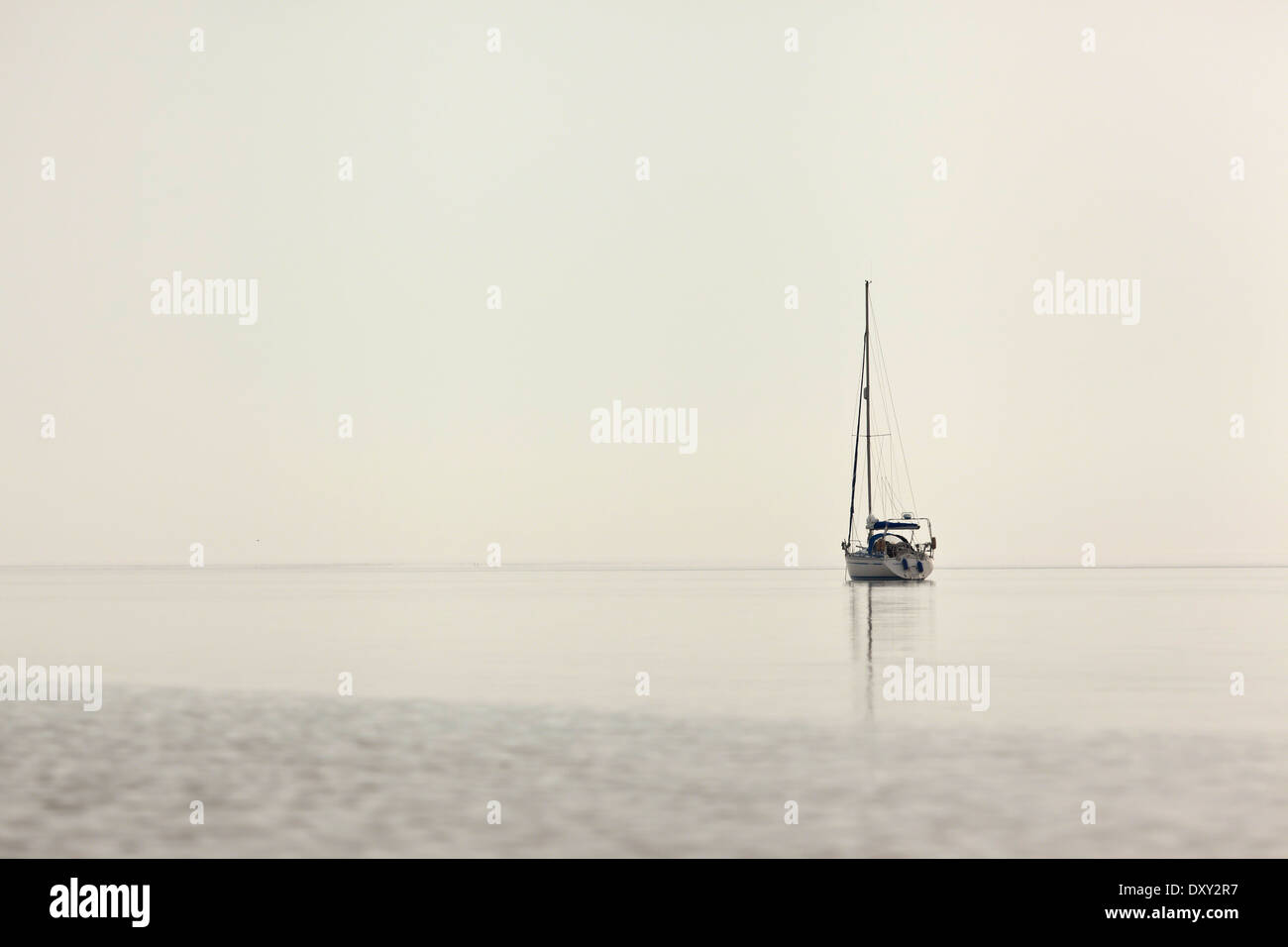 A sailing boat with its sails down resting on a quiet river Stock Photo ...