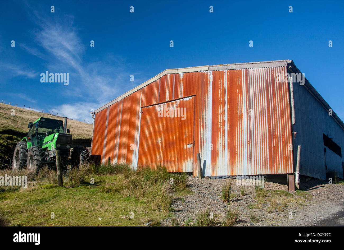 Rusty rusting rusted corrugated iron farm shed with tractor parked ...