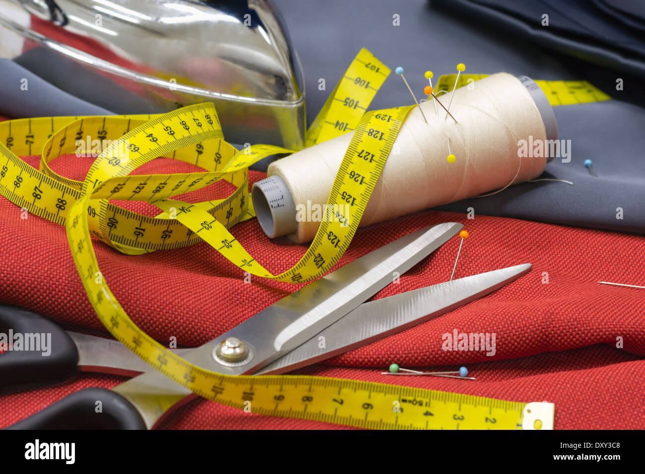 Tailors tools - thread spools, pin, scissors and yellow measuring tape ...