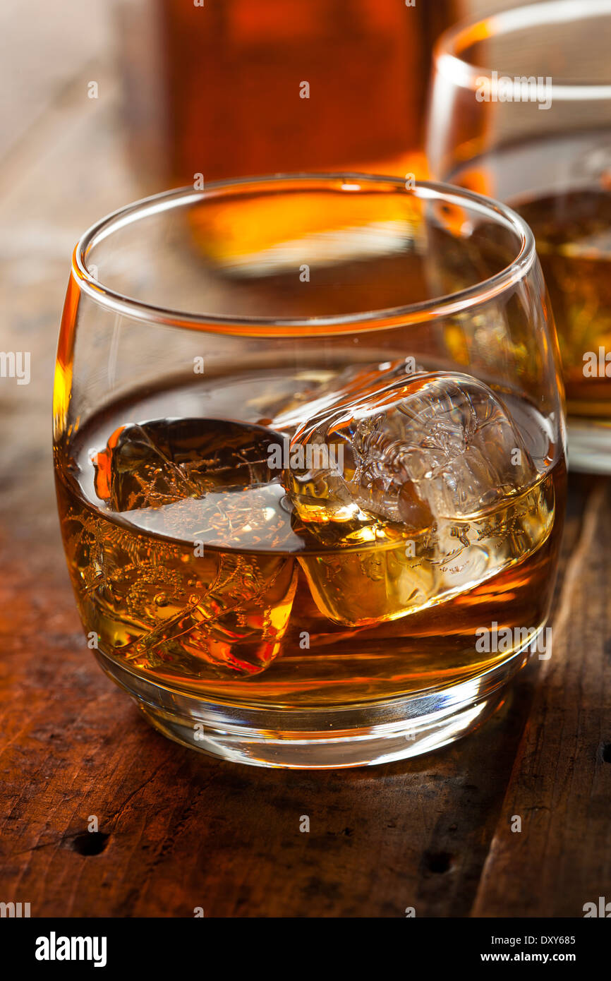 Alcoholic Amber Whiskey Bourbon in a Glass with Ice Stock Photo - Alamy