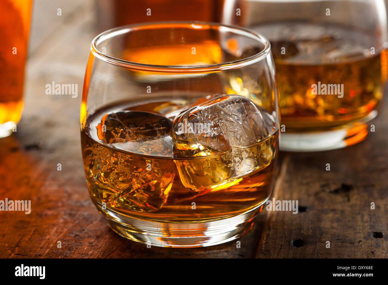 Alcoholic Amber Whiskey Bourbon in a Glass with Ice Stock Photo - Alamy