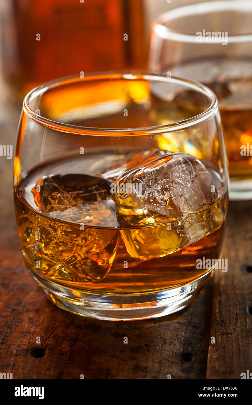 Alcoholic Amber Whiskey Bourbon in a Glass with Ice Stock Photo - Alamy