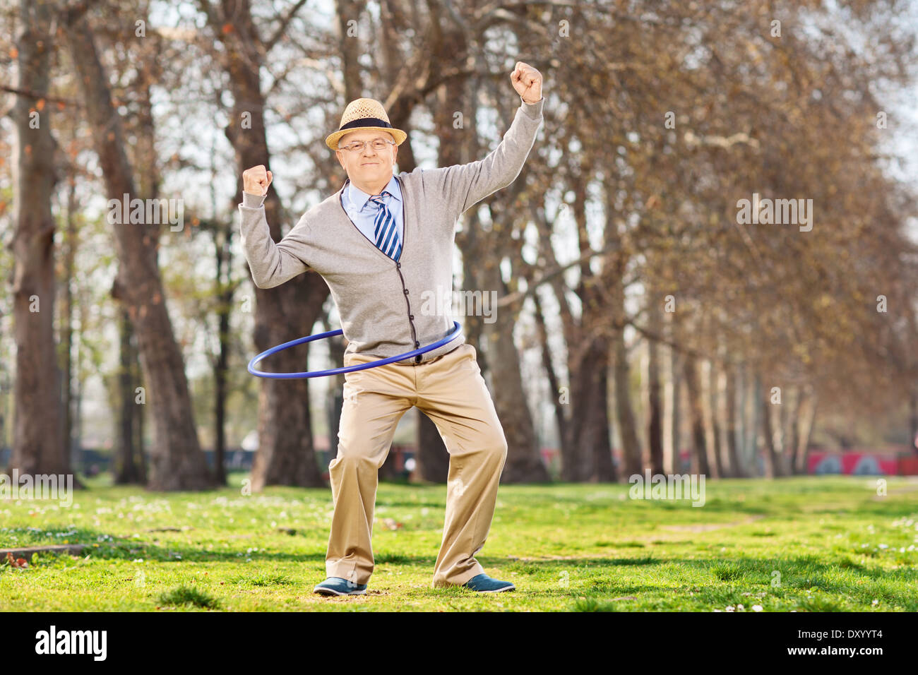 Senior man, exercise with a hula hoop and gesture happiness in park ...