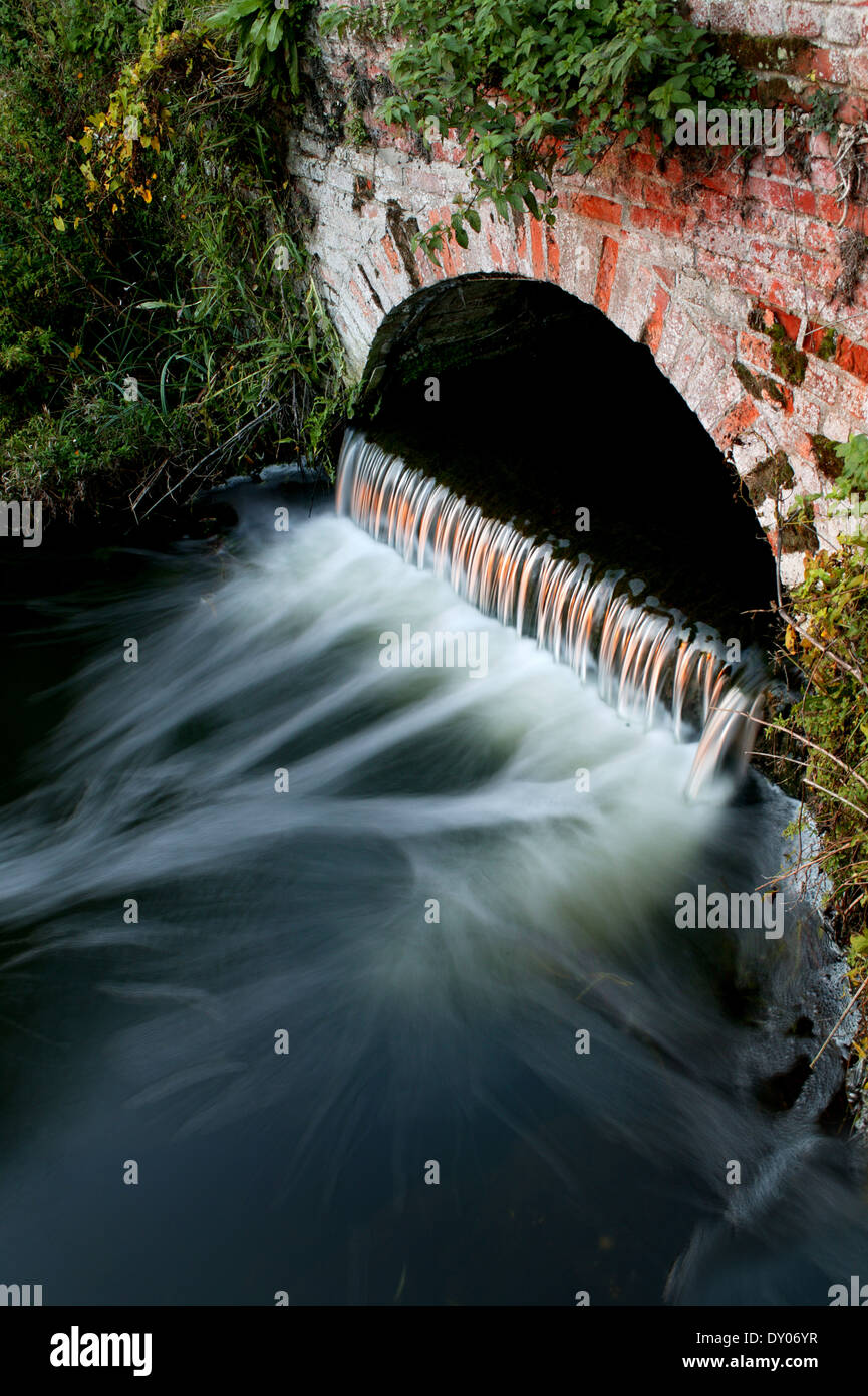 slow exposure waterfall with orange sunset colors within the water ...