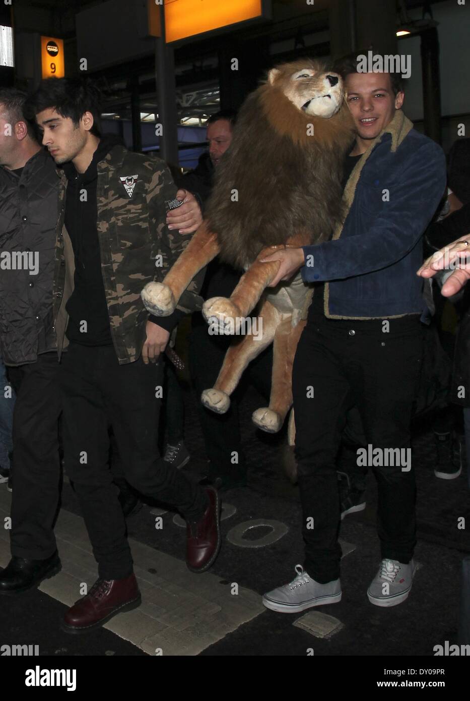 One Direction arrive at a manic Heathrow Terminal 5 holding giant ...