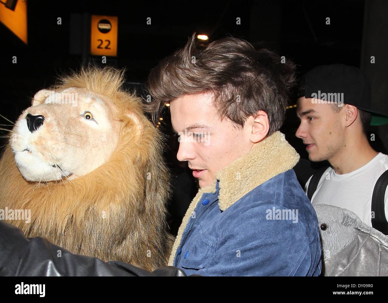 One Direction arrive at a manic Heathrow Terminal 5 holding giant ...