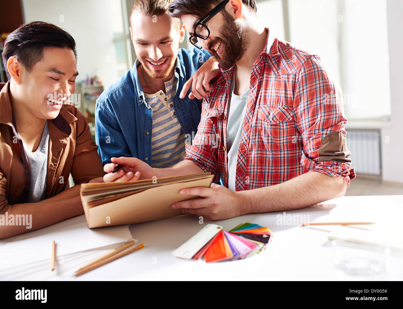 Smiling guys discussing ideas of new color for their hostel room Stock ...