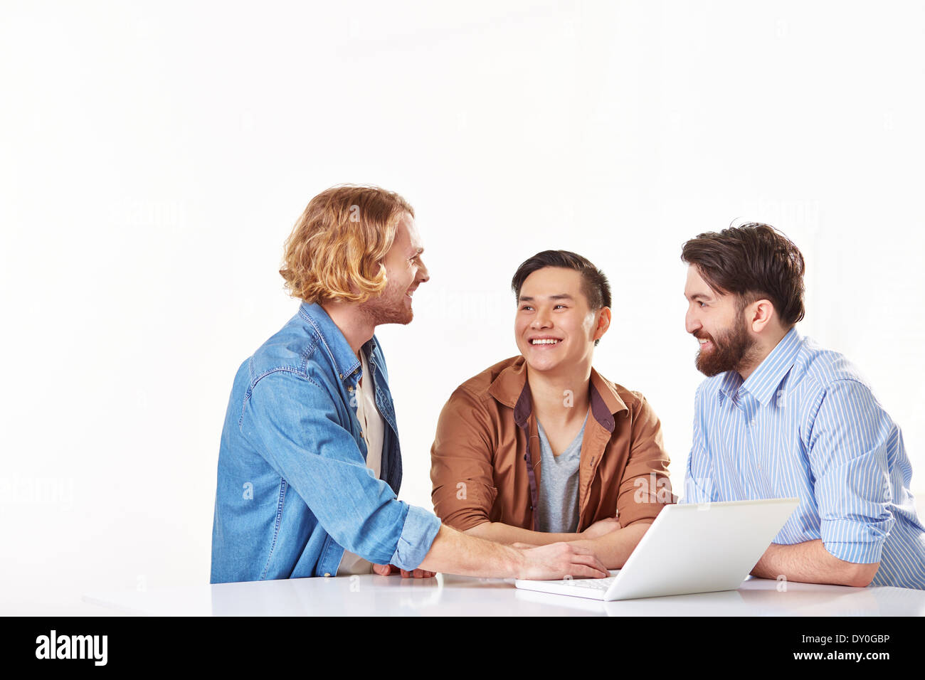 Group of friendly men using laptop and interacting Stock Photo - Alamy
