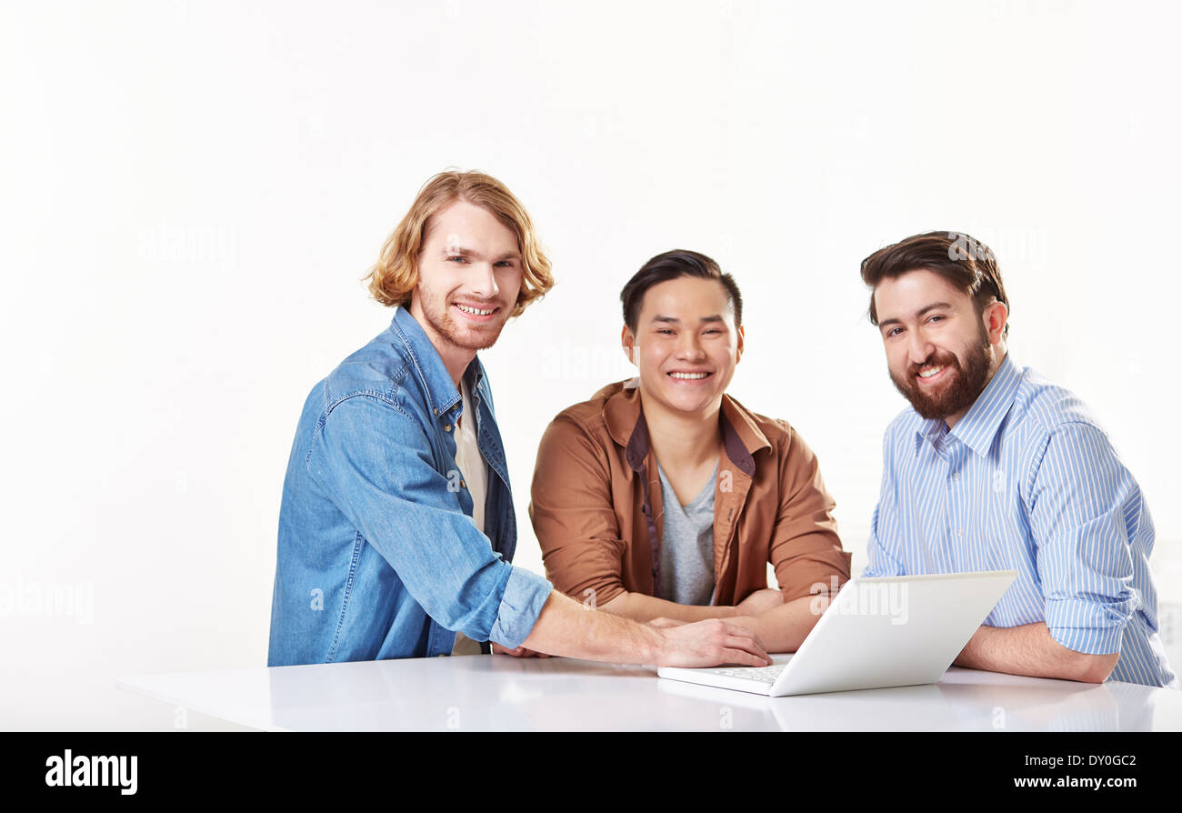 Group of friendly men with laptop looking at camera Stock Photo - Alamy