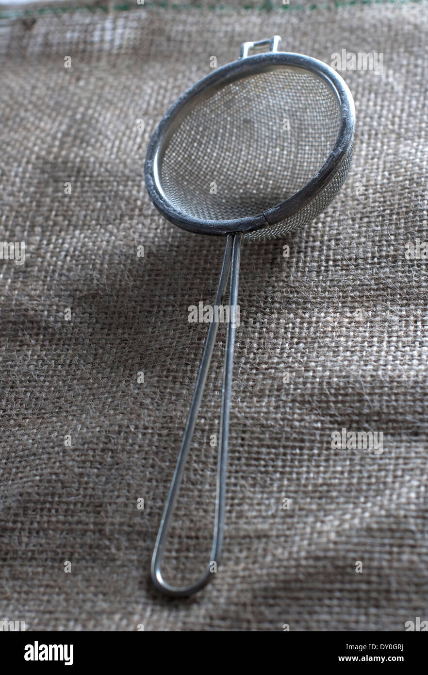 Still life food image of a small sieve on a hessian background Stock ...
