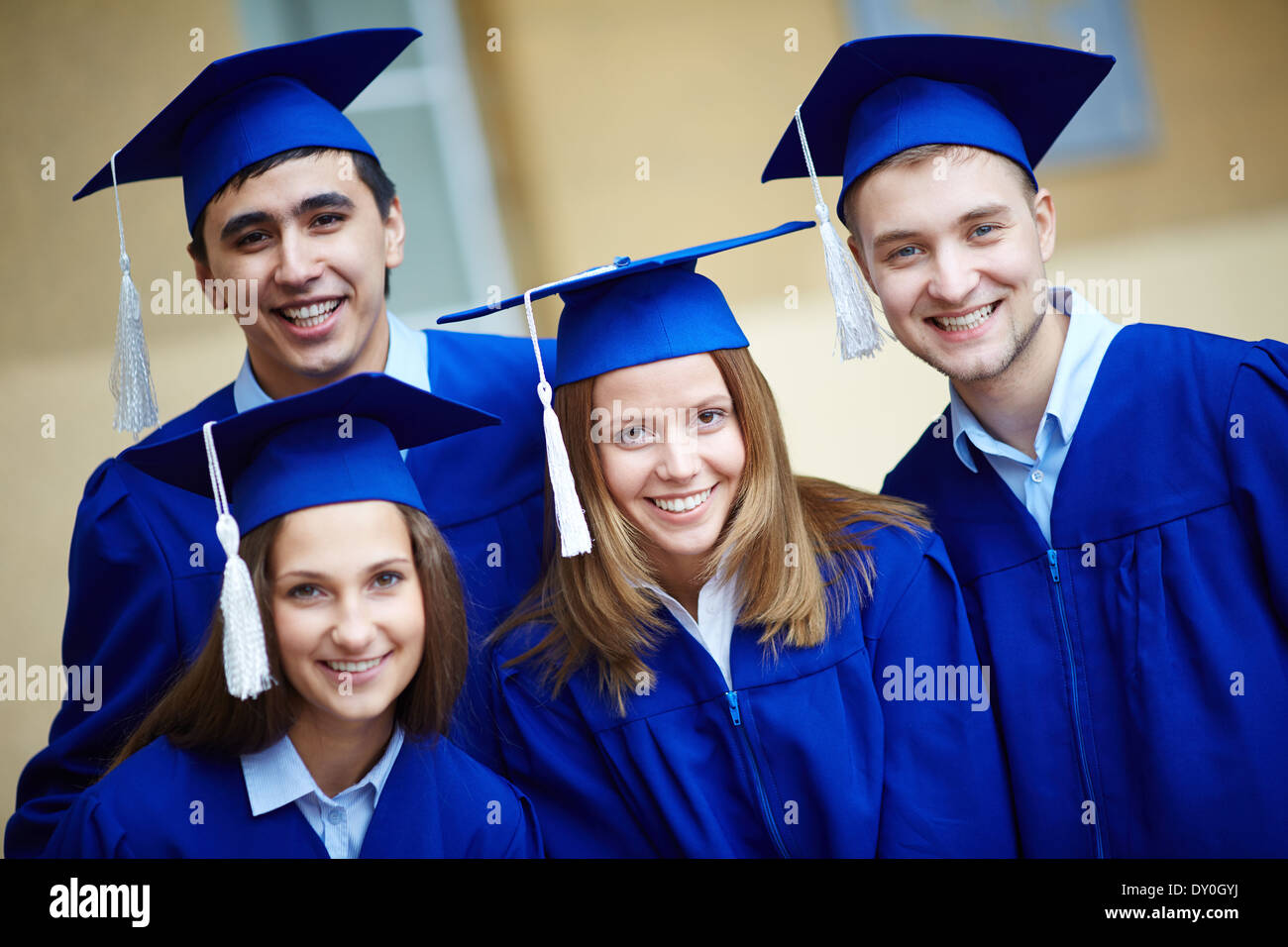 Friendly students in graduation gowns looking at camera Stock Photo - Alamy