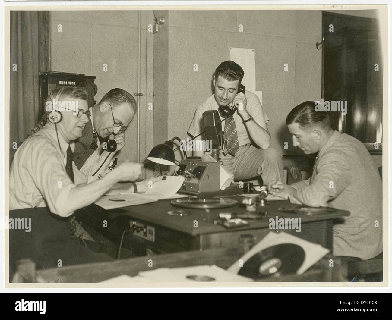 This photograph captures a group of radio producers in a studio during ...