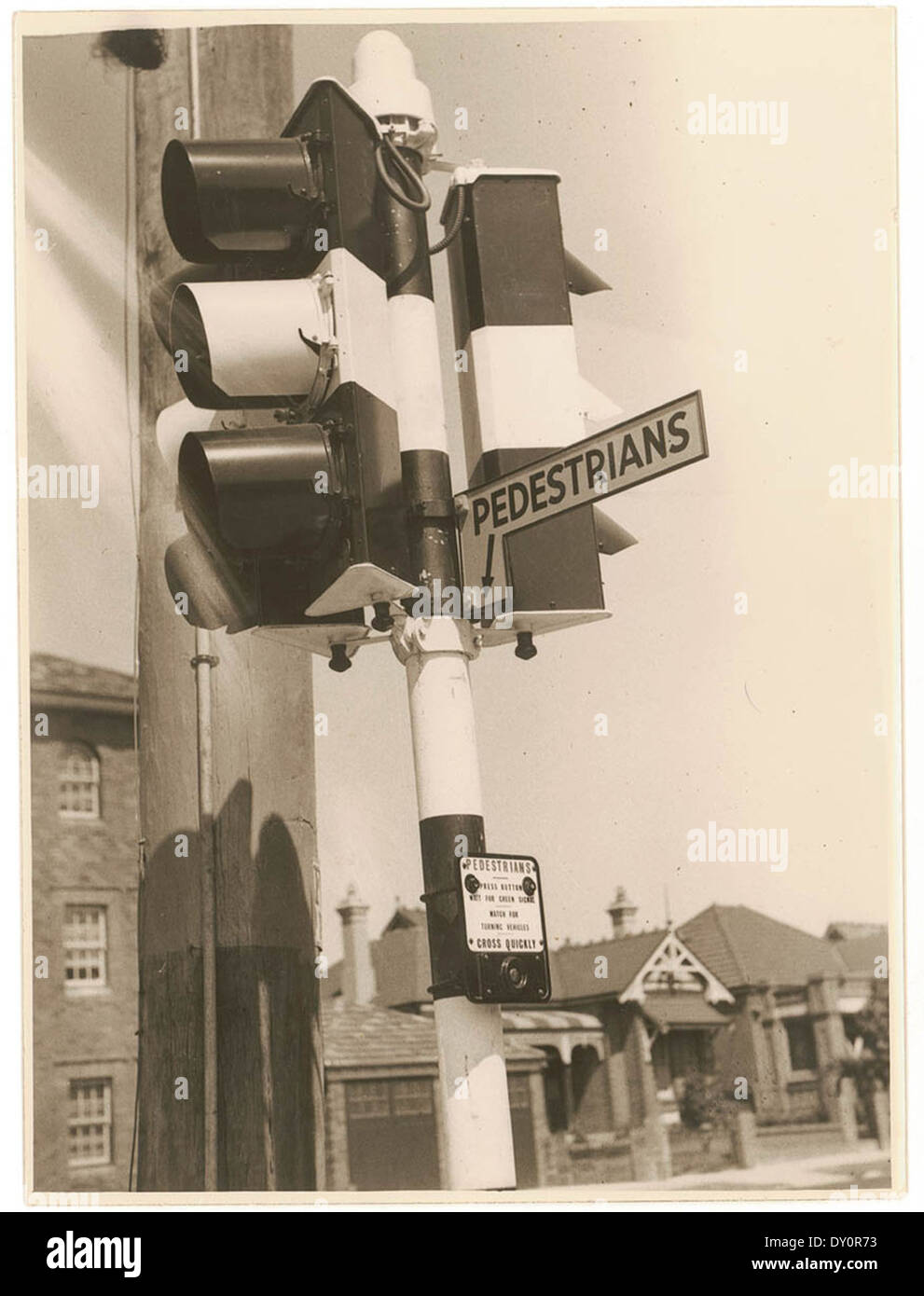 This photograph by Sam Hood shows early motor and pedestrian traffic ...