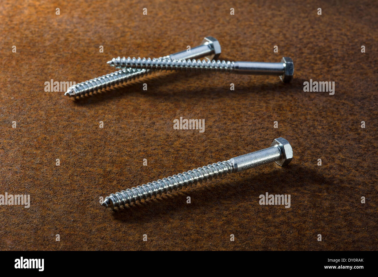 Three zinc plated coach screws on a rusty, sheet metal background Stock ...