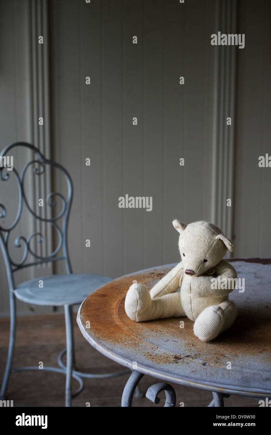 Thoughtful Teddy bear sat on a seat in a garden summer house Stock ...