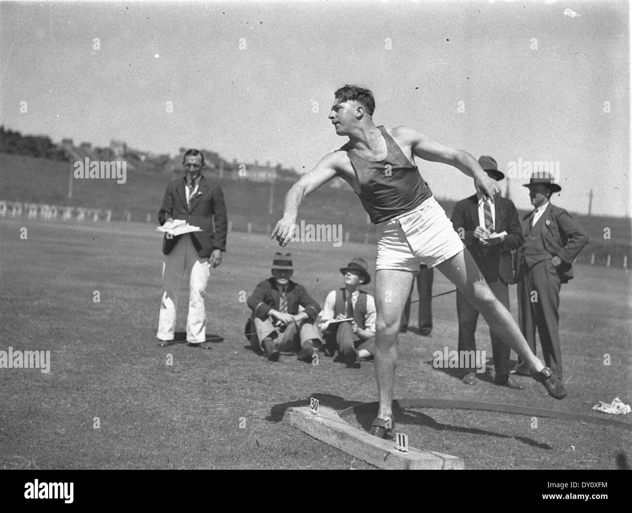 This photograph from 1935 captures W. Plummer winning the 16 lb. shot ...