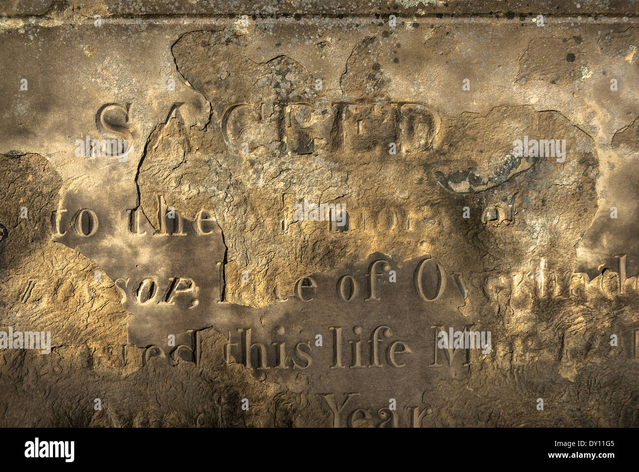 A very old gravestone showing detail of crumbling lettering Stock Photo ...