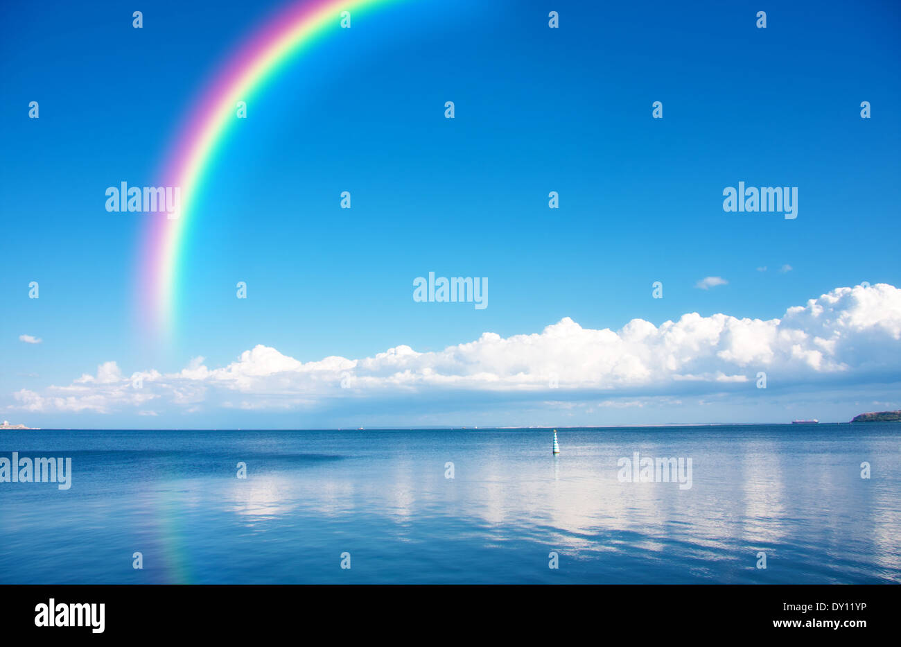 Rainbow on blue sky over endless water Stock Photo - Alamy