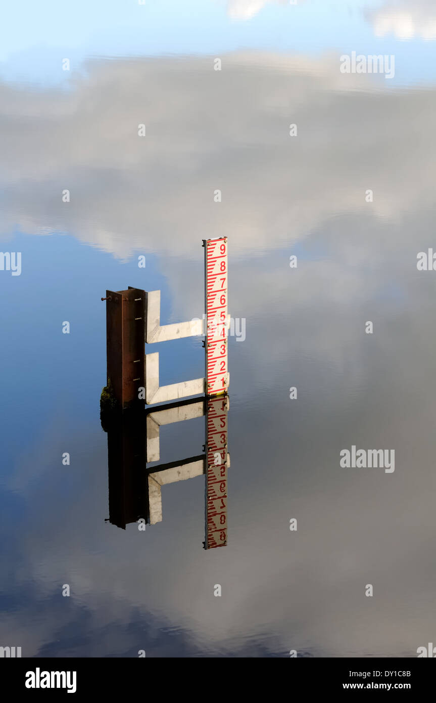 Still water reflection of depth measurement gauge Stock Photo - Alamy