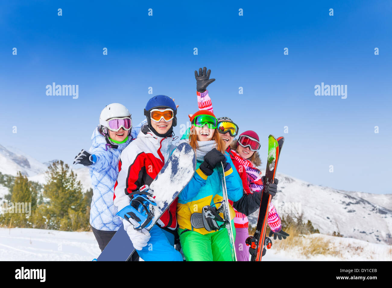 Five happy friends with snowboards and skis Stock Photo - Alamy
