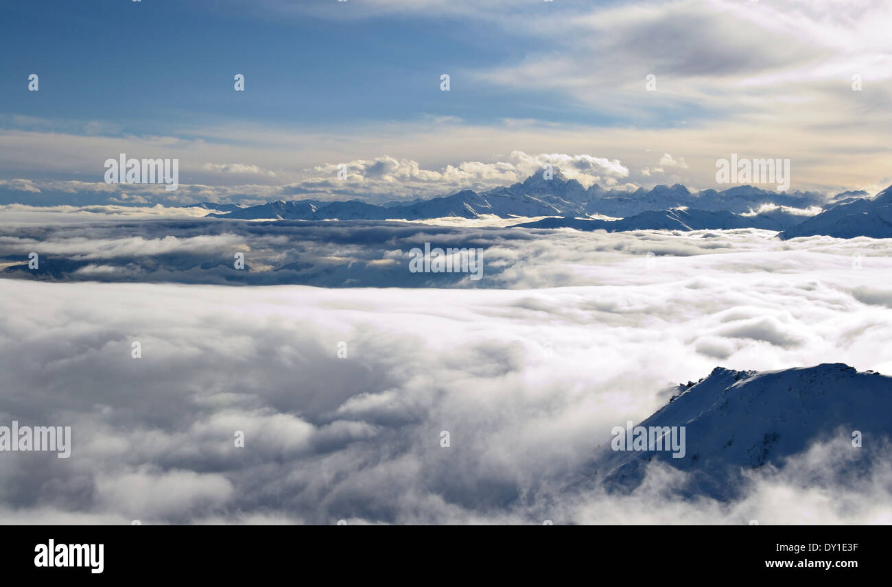 Aerial view of the alpine arc in a winter scenery with foggy valleys ...