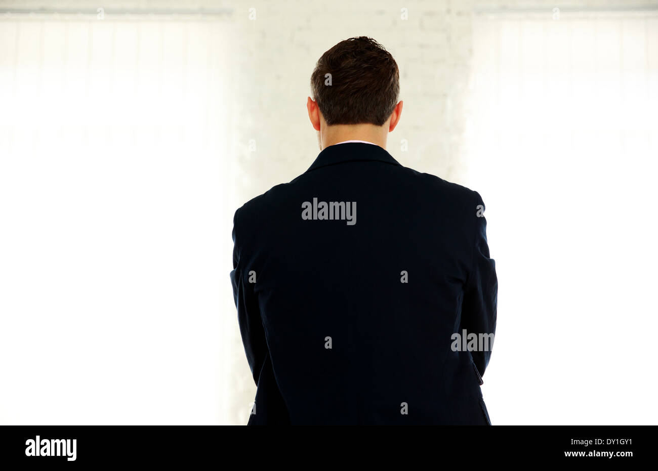 Back view portrait of a businessman standing in office Stock Photo - Alamy