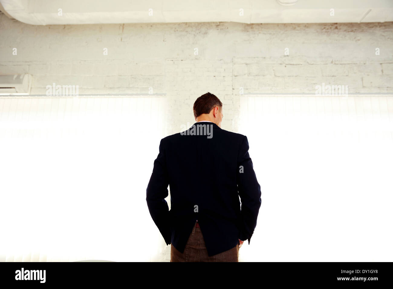 Back view portrait of a businessman standing in office Stock Photo - Alamy