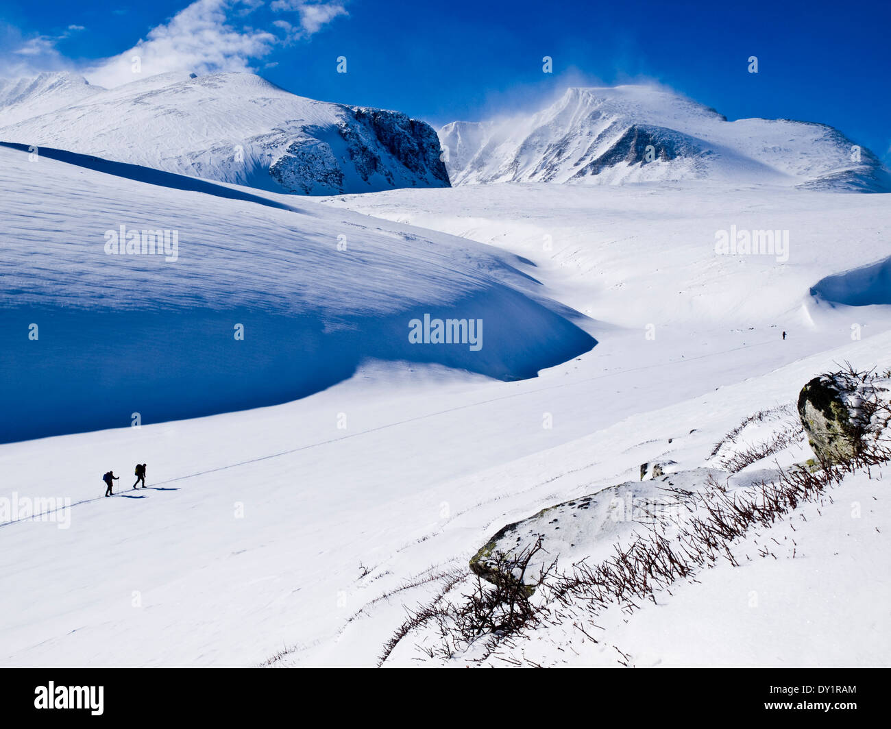 ski touring in the Rondane, Norway. Vast snow covered mountains dwarf ...