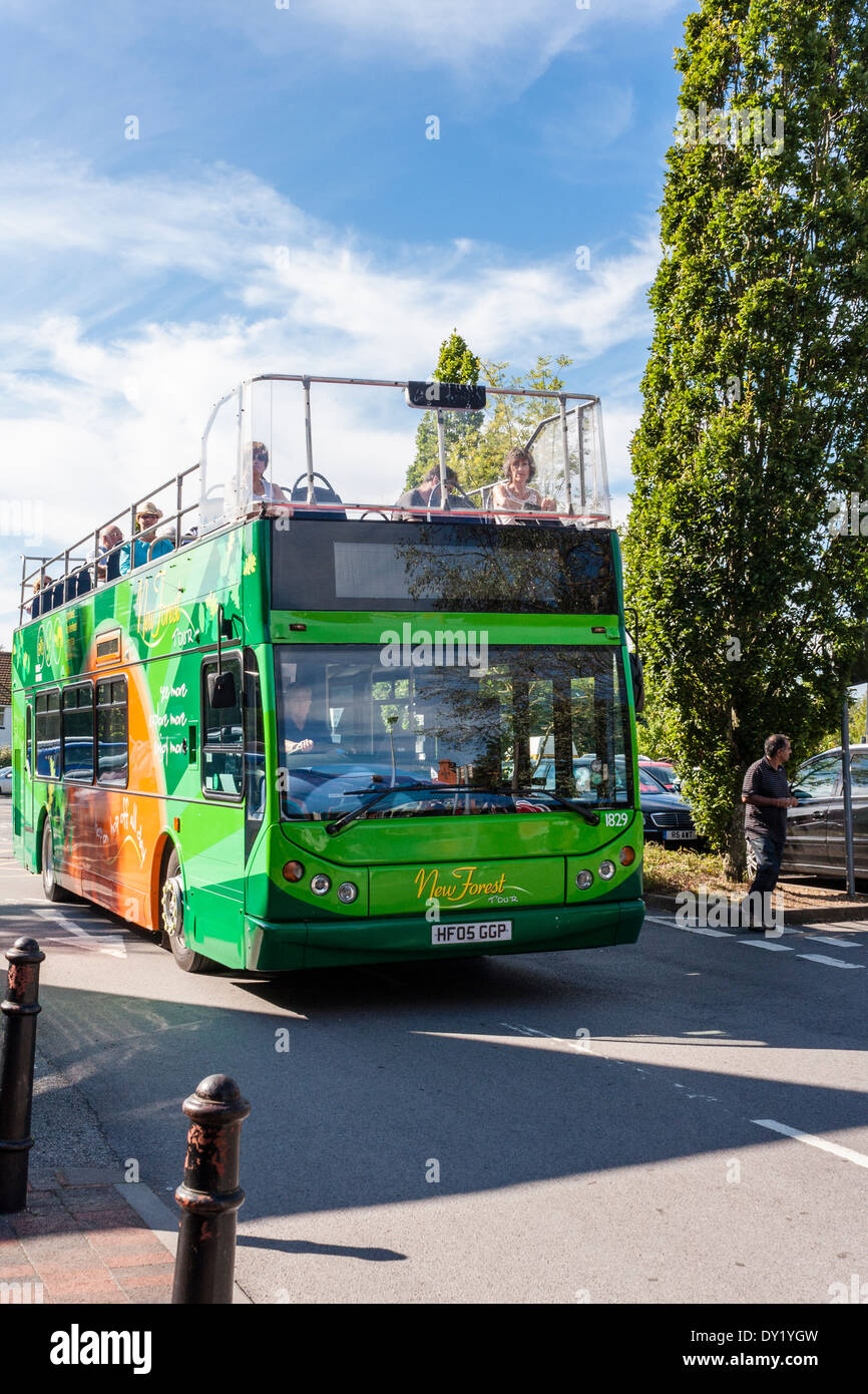 Sightseers on an open top double-decker tour bus. New Forest, Lyndhurst ...