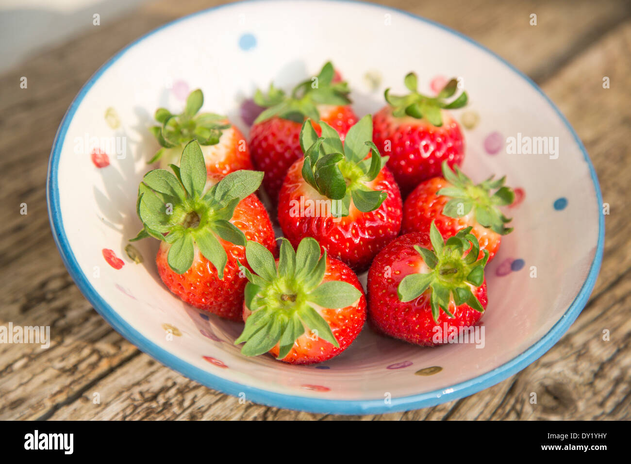 Whole Spanish strawberries in a ceramic rustic bowl, placed on rustic ...