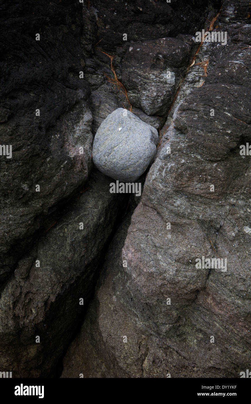 Tumbled rock from tidal action wedged within a rock crevice at Hot ...