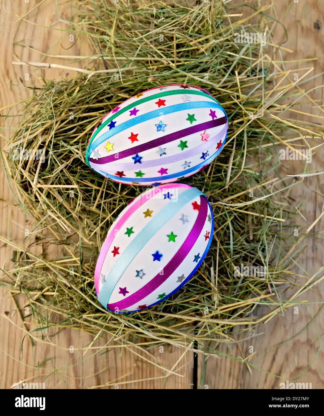 Two easter eggs, decorated with multicolored braid and sparkles in the ...