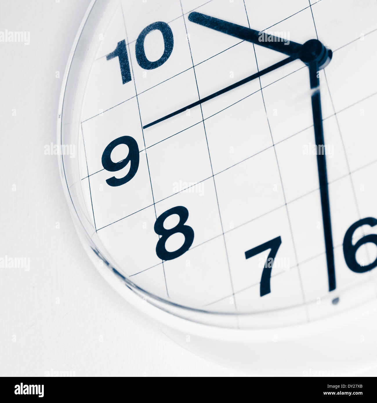 Analog wall clock, narrow focus on number nine, tinted black and white ...