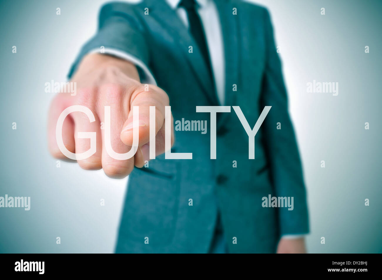 man wearing a suit pointing the finger to the word guilty written in ...