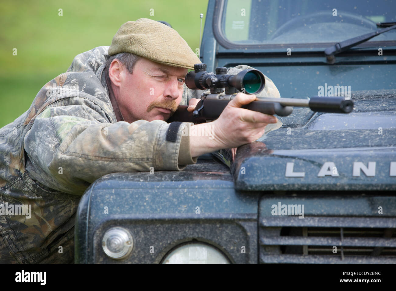 A Game Keeper shooting pests during the day from a Land Rover vehicle ...