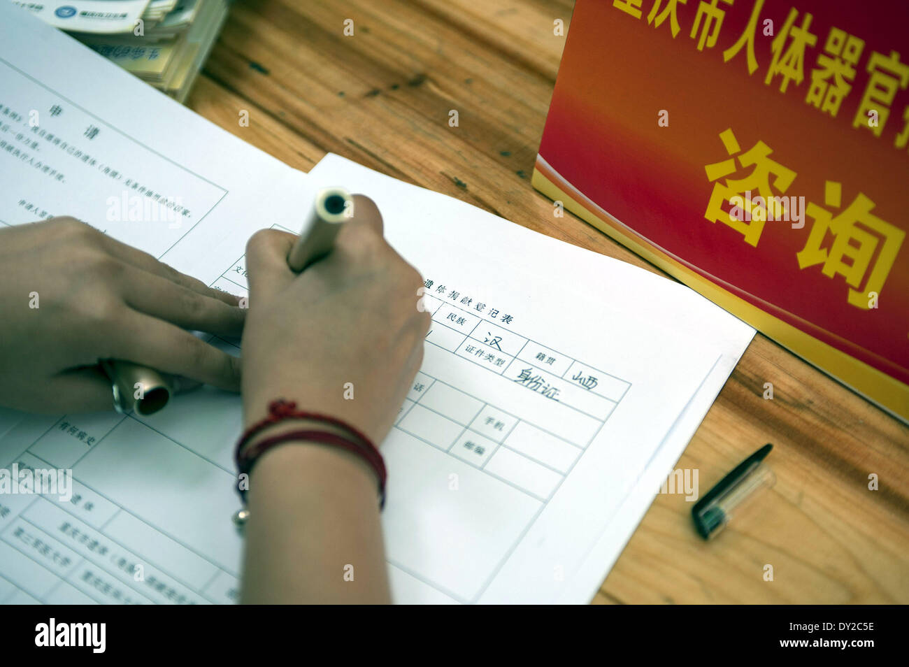 Chongqing. 4th Apr, 2014. A citizen fills in a body donation chart ...