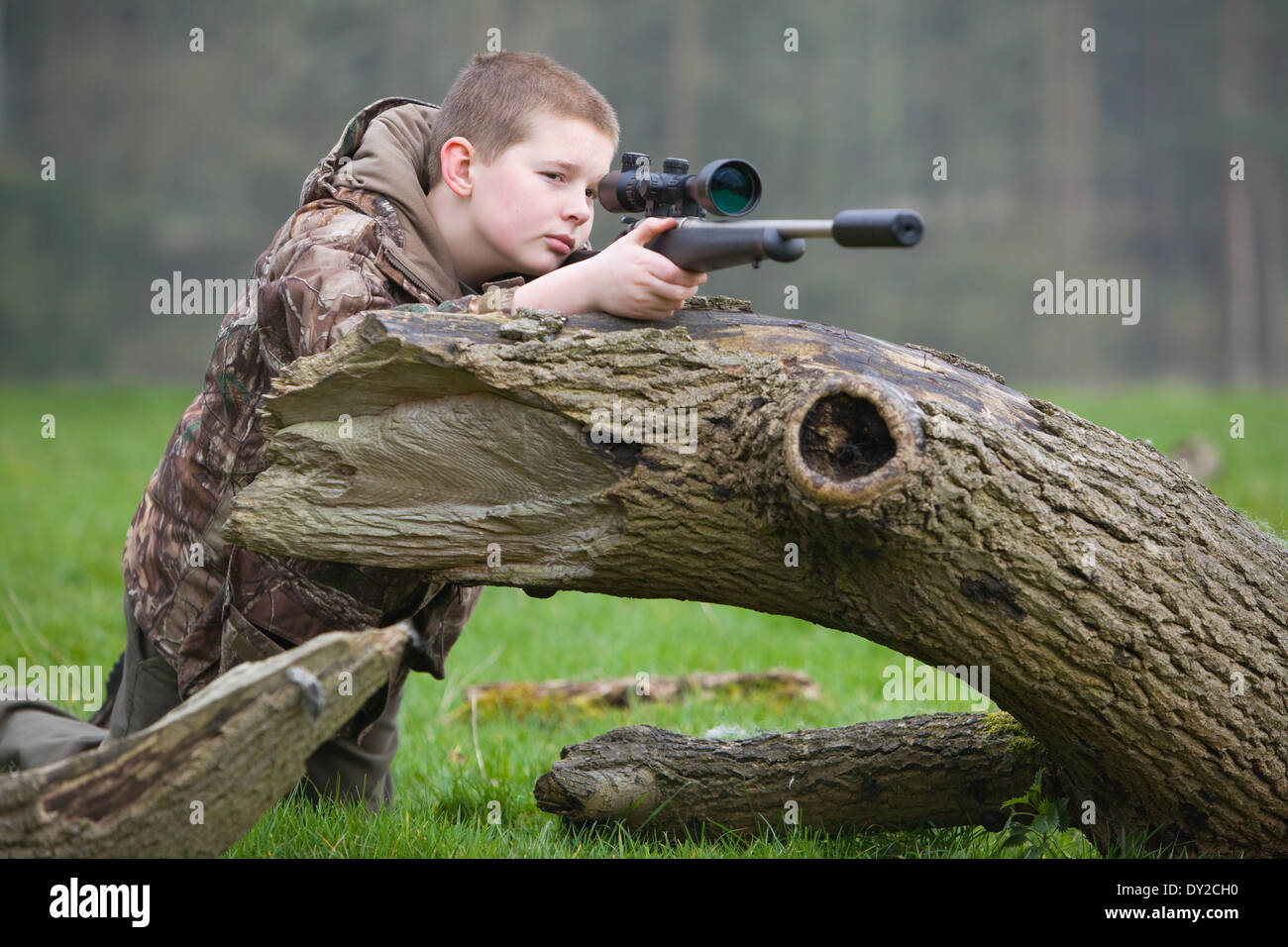 A young man with a rifle, shooting pests during the day in the ...