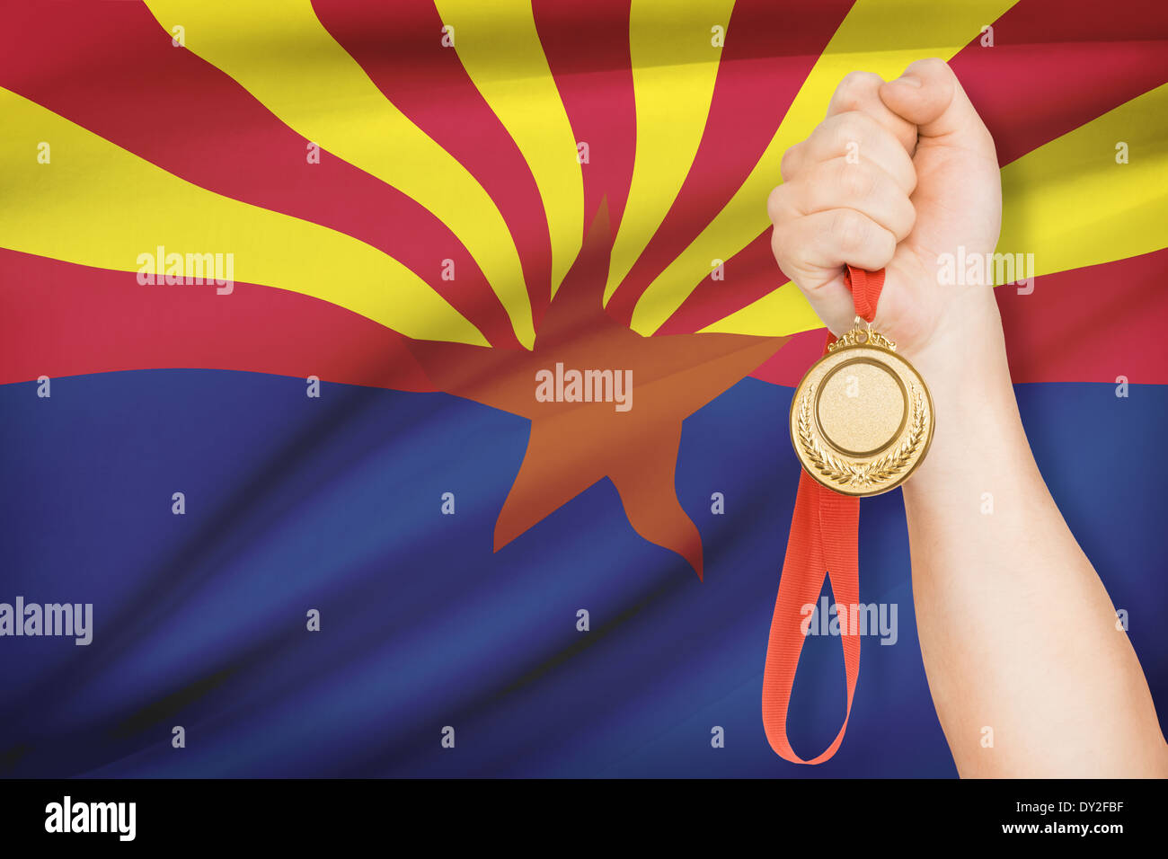 Sportsman holding gold medal with State of Arizona flag on background ...