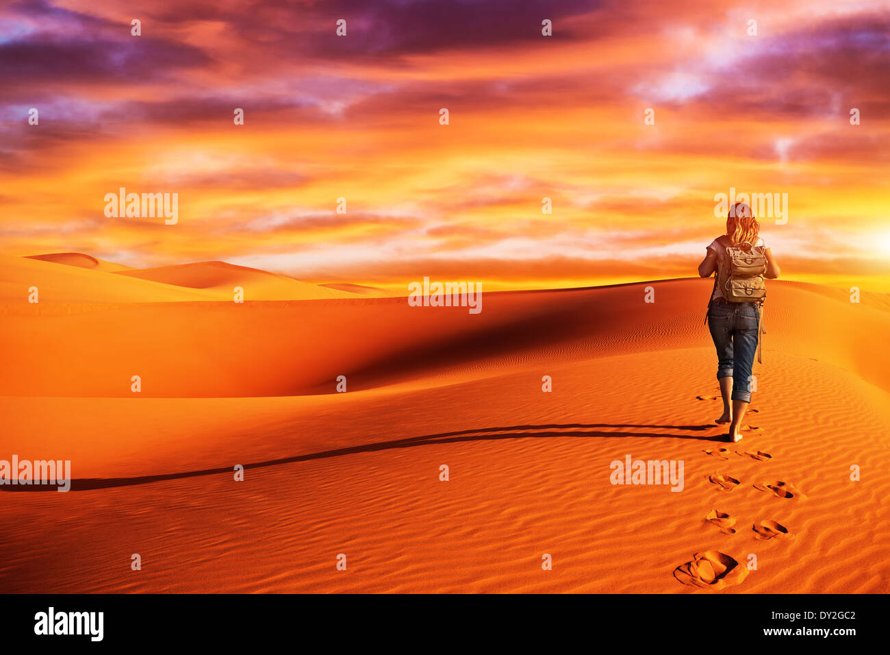 Active woman trekking along desert, walking alone in the dune ...